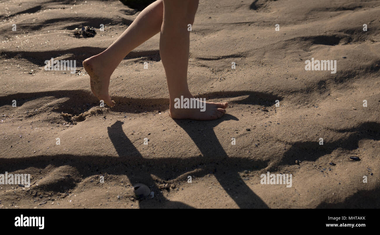 Woman walking on sand at beach Stock Photo - Alamy