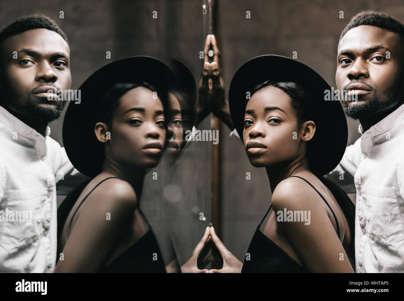 stylish Lovely african newlyweds posing at big mirror in hotel room ...