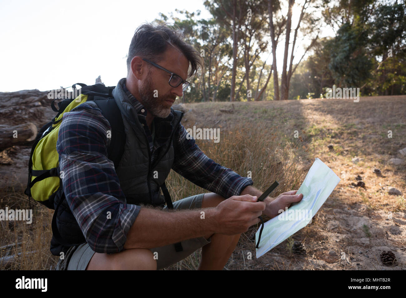 Man looking at map in forest Stock Photo - Alamy