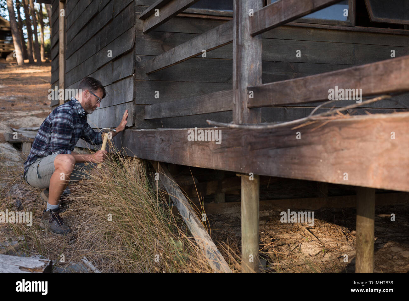 Man hammering wooden plank with hammer Stock Photo - Alamy