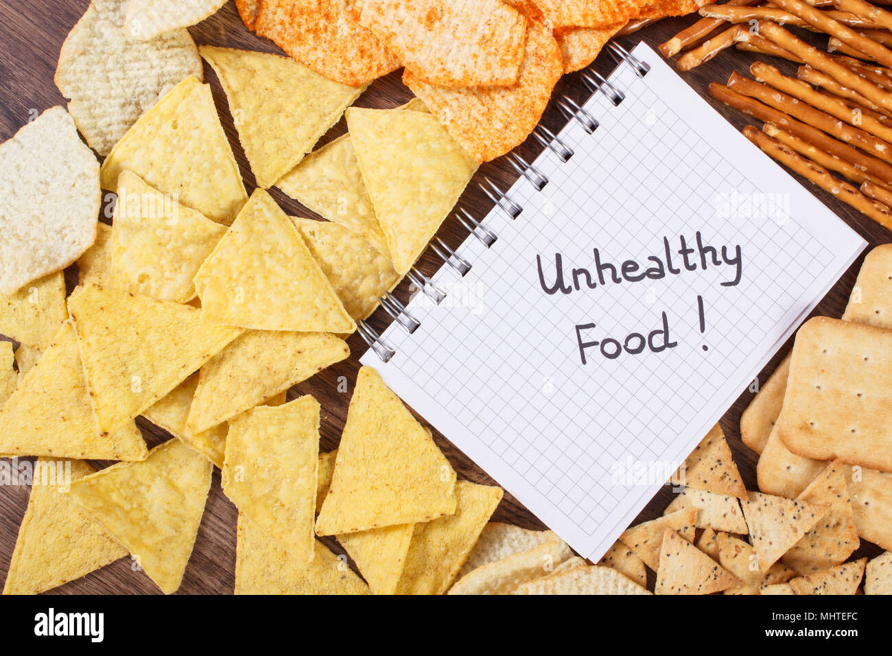 Inscription unhealthy food in notebook, crunchy potato crisps ...