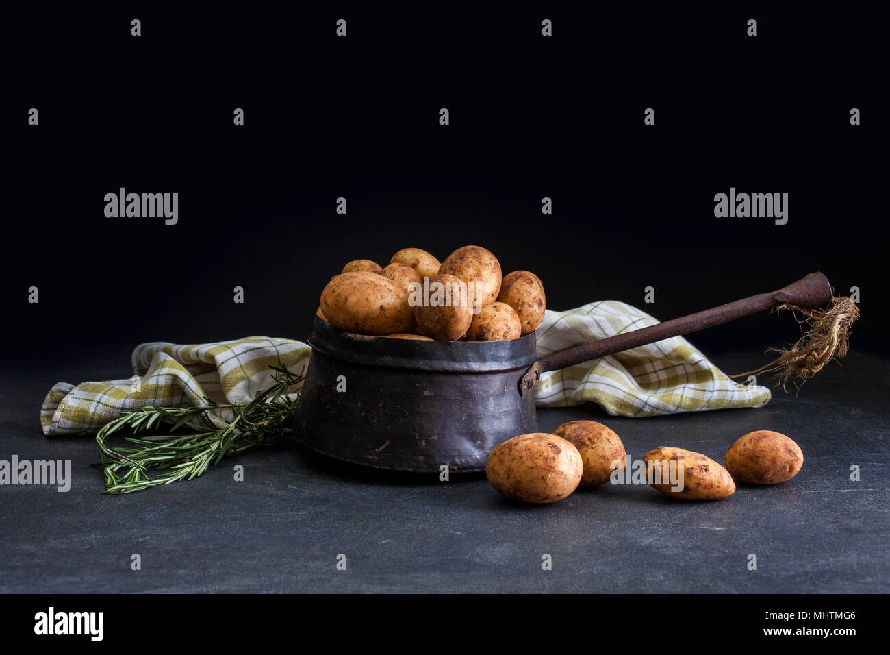 View of new earthy potatoes on dark background Stock Photo - Alamy