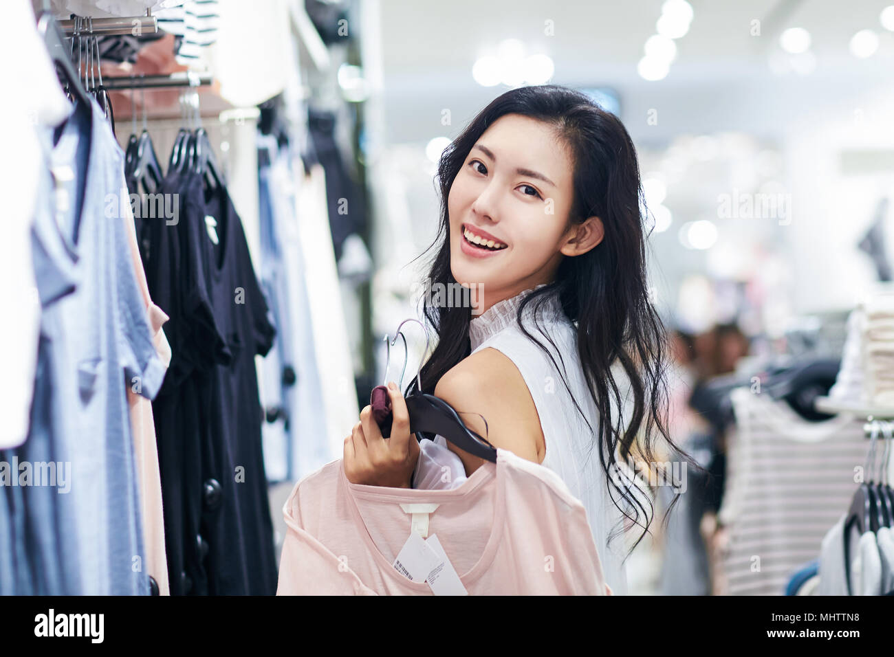 Young woman chooses clothes in a clothing store Stock Photo - Alamy