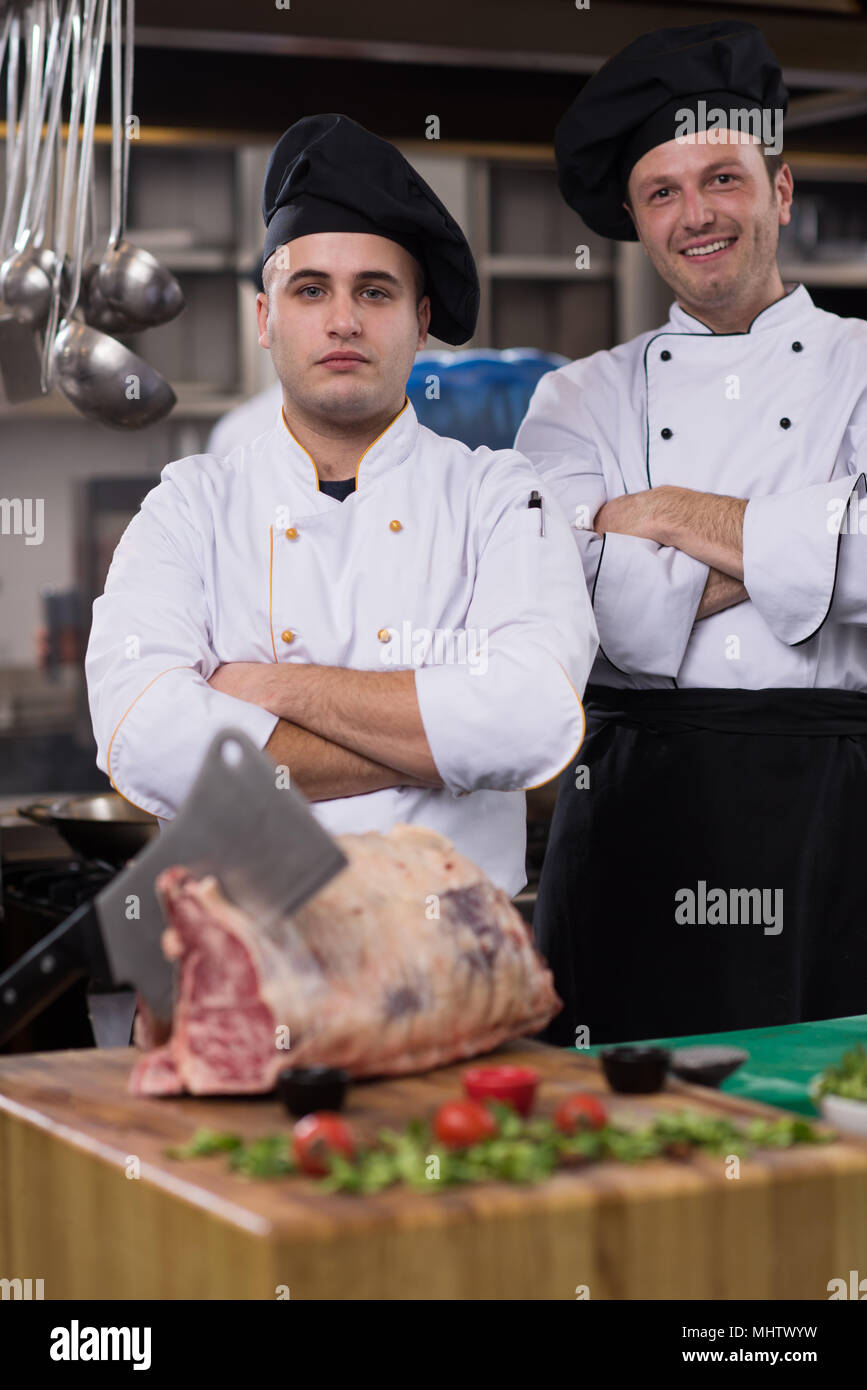 Portrait of two chefs standing together in commercial kitchen at ...