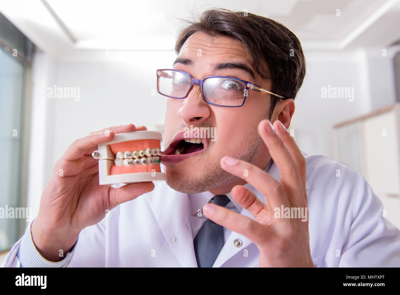 Funny dentist with teeth model in hospital Stock Photo - Alamy