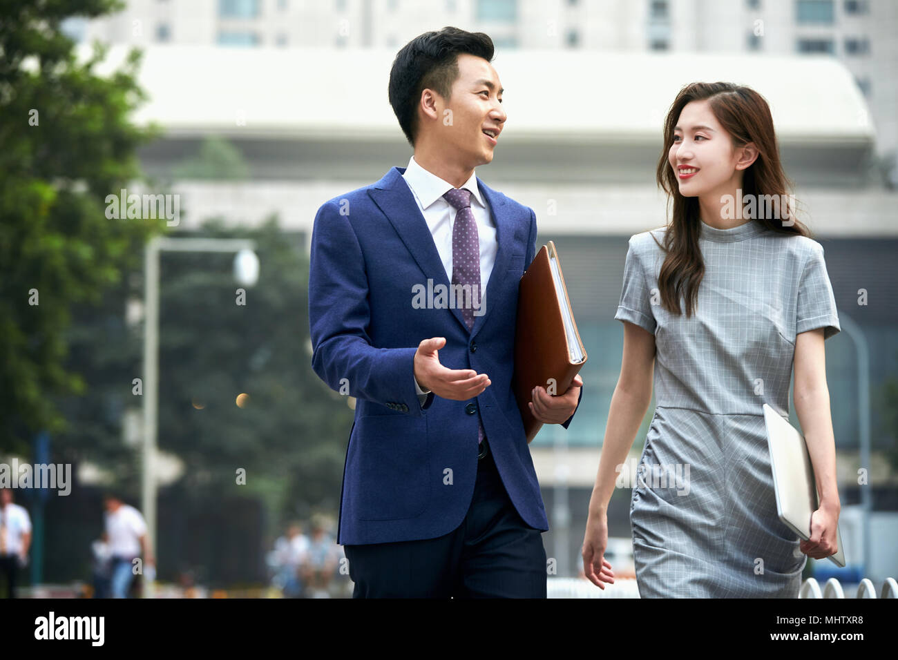 Business people walk while talking about Stock Photo - Alamy