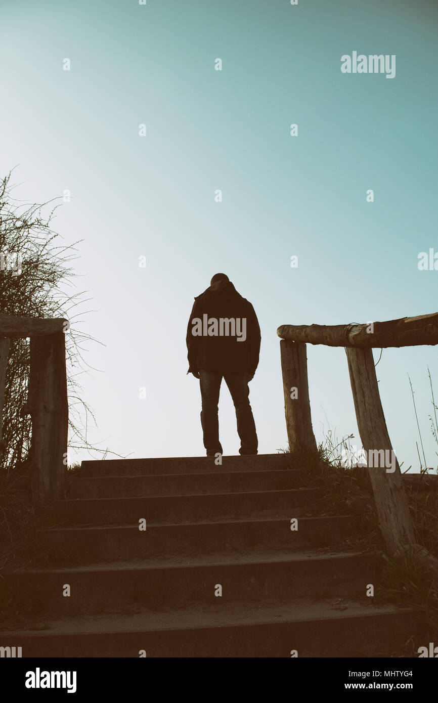 Rear view of a mysterious male figure standing outdoors Stock Photo - Alamy