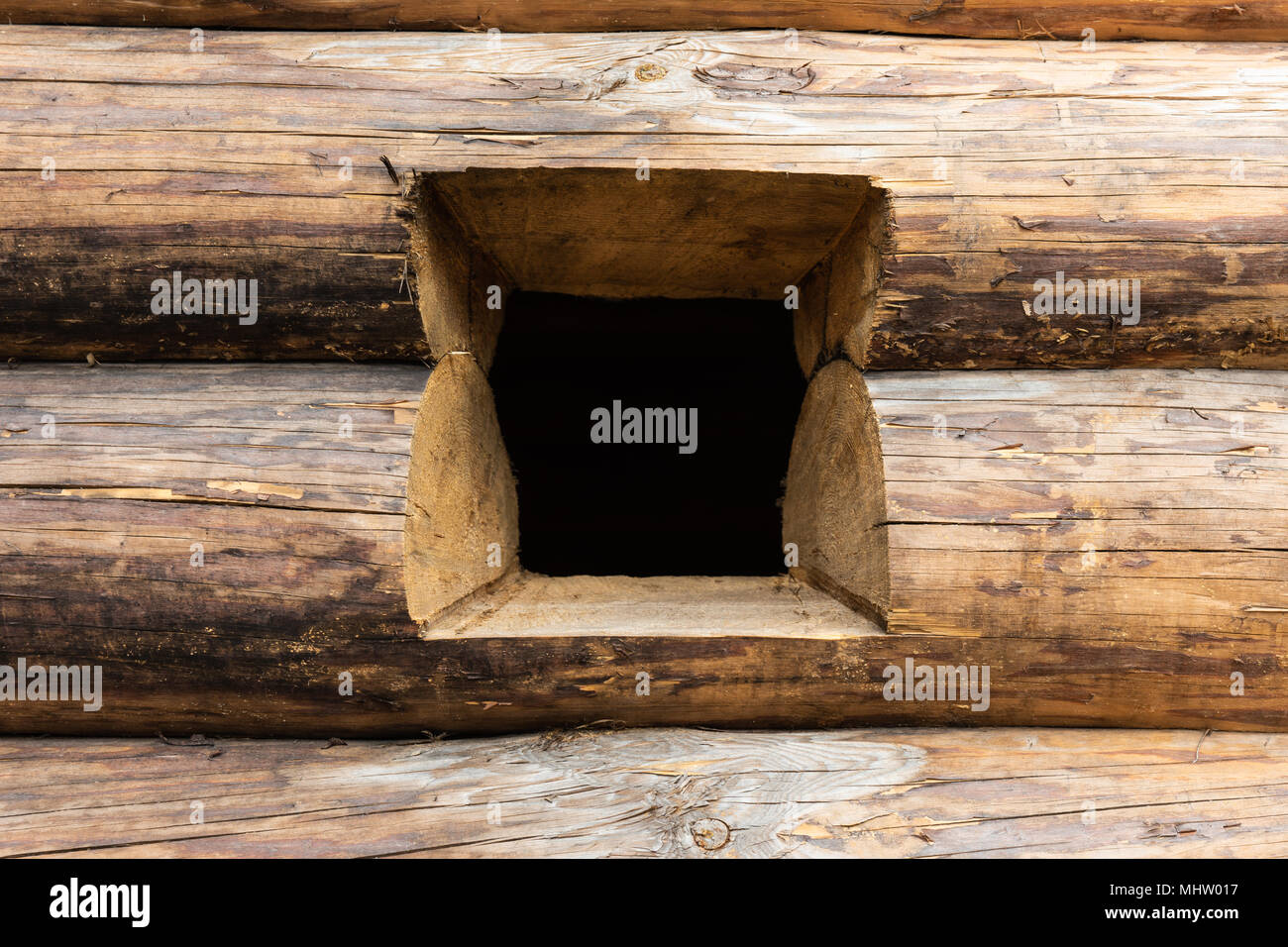 Detail of an ancient wooden wall with a square gun or arrow hole of ...