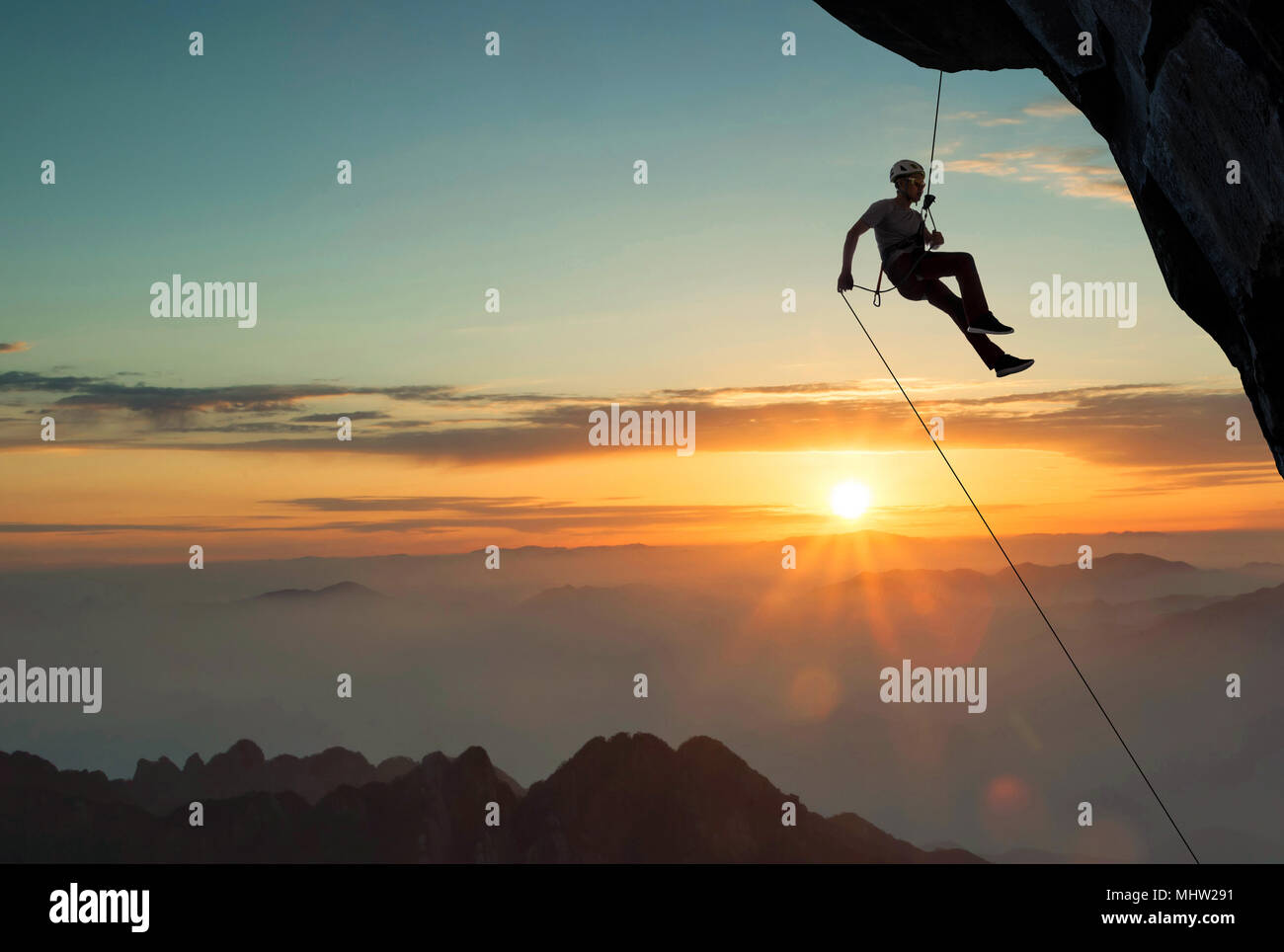 Middle-aged man climbing over a cliff Stock Photo - Alamy