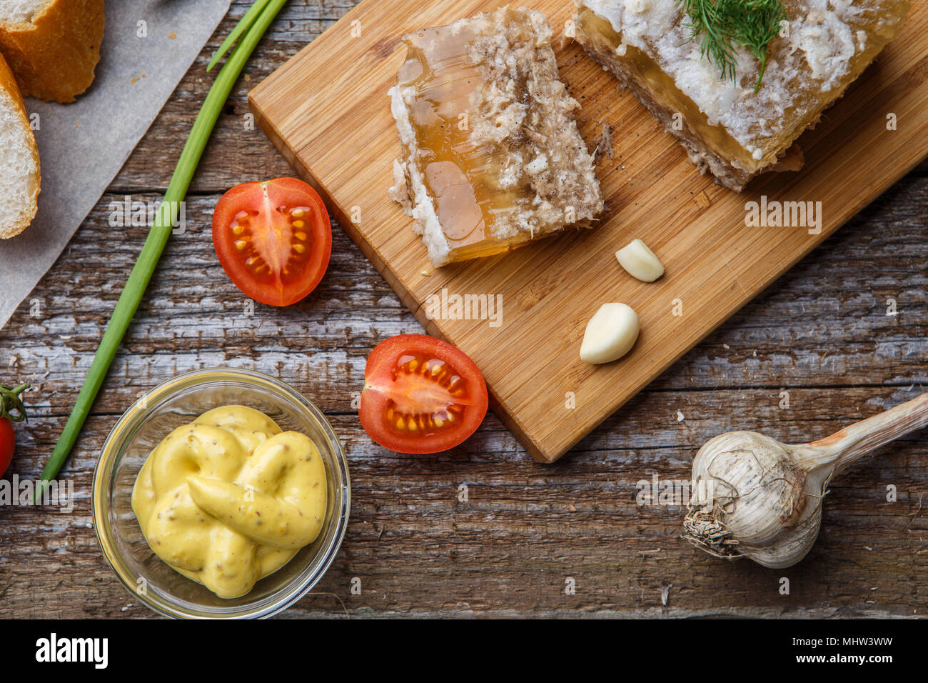 Homemade jelly meat with mustard, bread, tomatoes and garlic on the ...