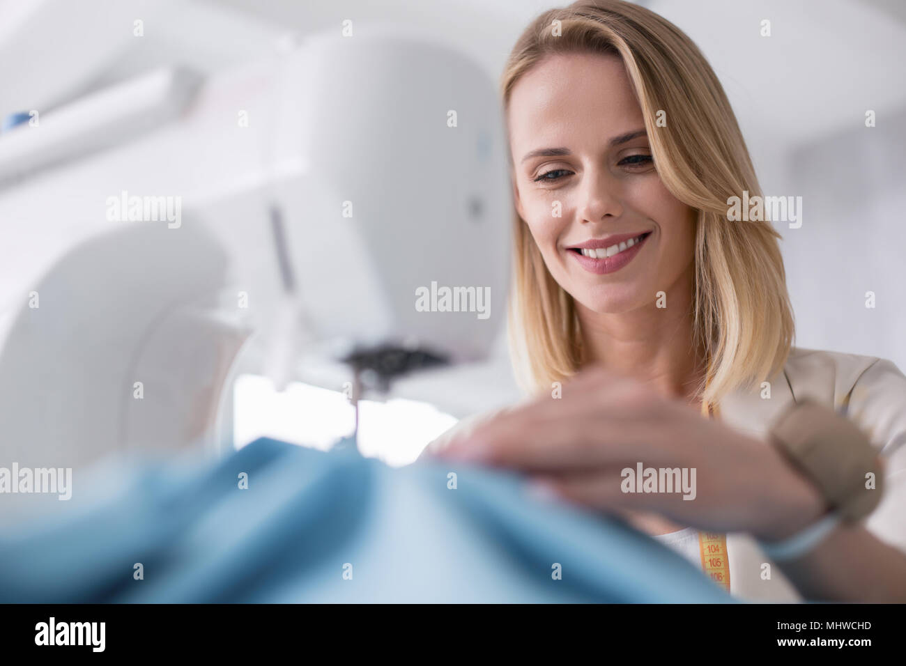 Merry female tailor making stitches Stock Photo - Alamy