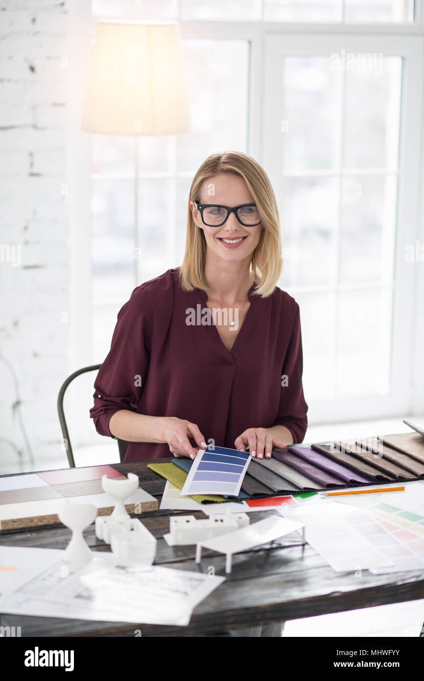 Pretty female designer comparing colors Stock Photo - Alamy