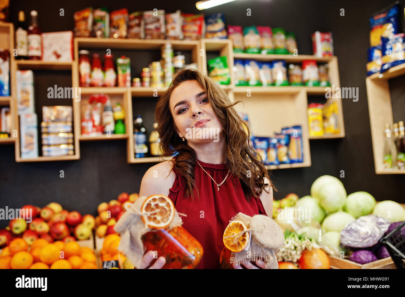 Girl in red holding jam in a jar on fruits store Stock Photo - Alamy