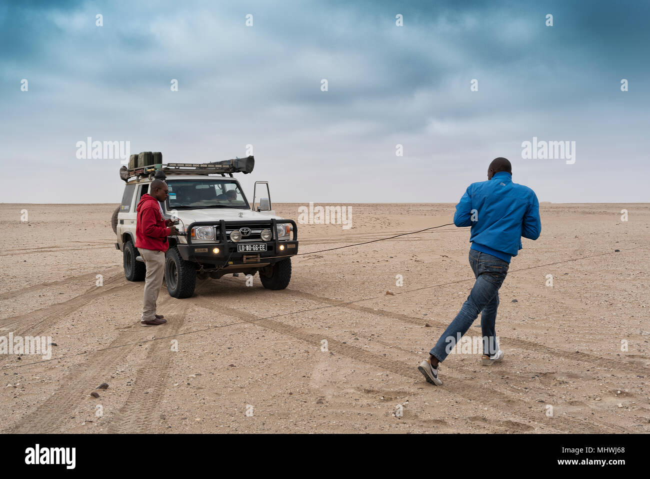 NAMIBE/ANGOLA - 26OCT2017 - men to dig up car in the desert Stock Photo ...