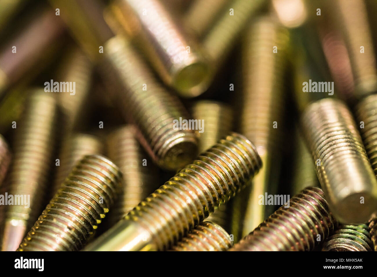 Close-up glossy brass bolts background. Brand new stainless screws or ...