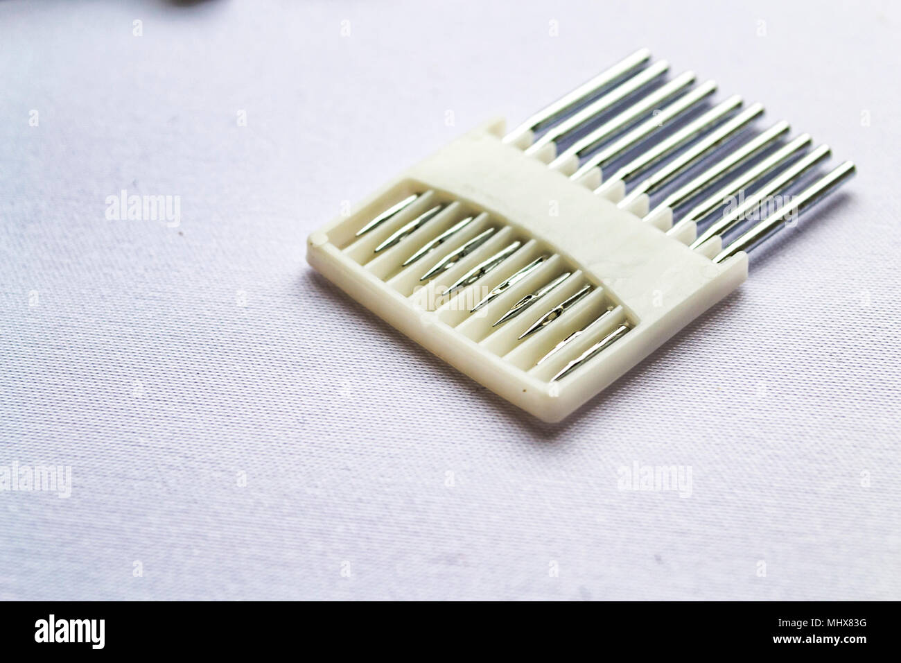 Sewing tools. Sewing needles set for sewing machine on white cotton ...