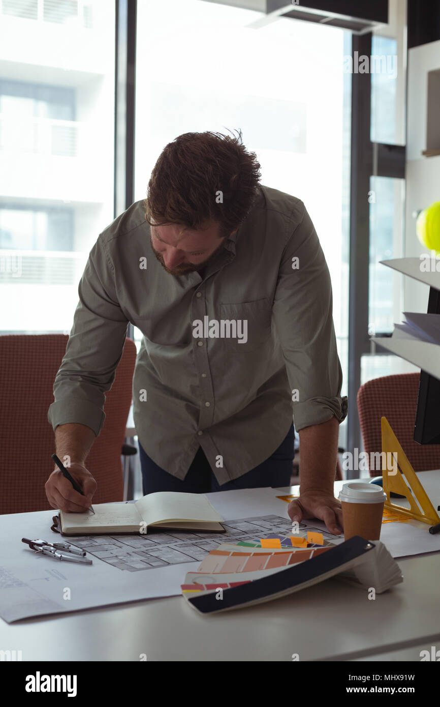 Architect writing note on diary Stock Photo - Alamy