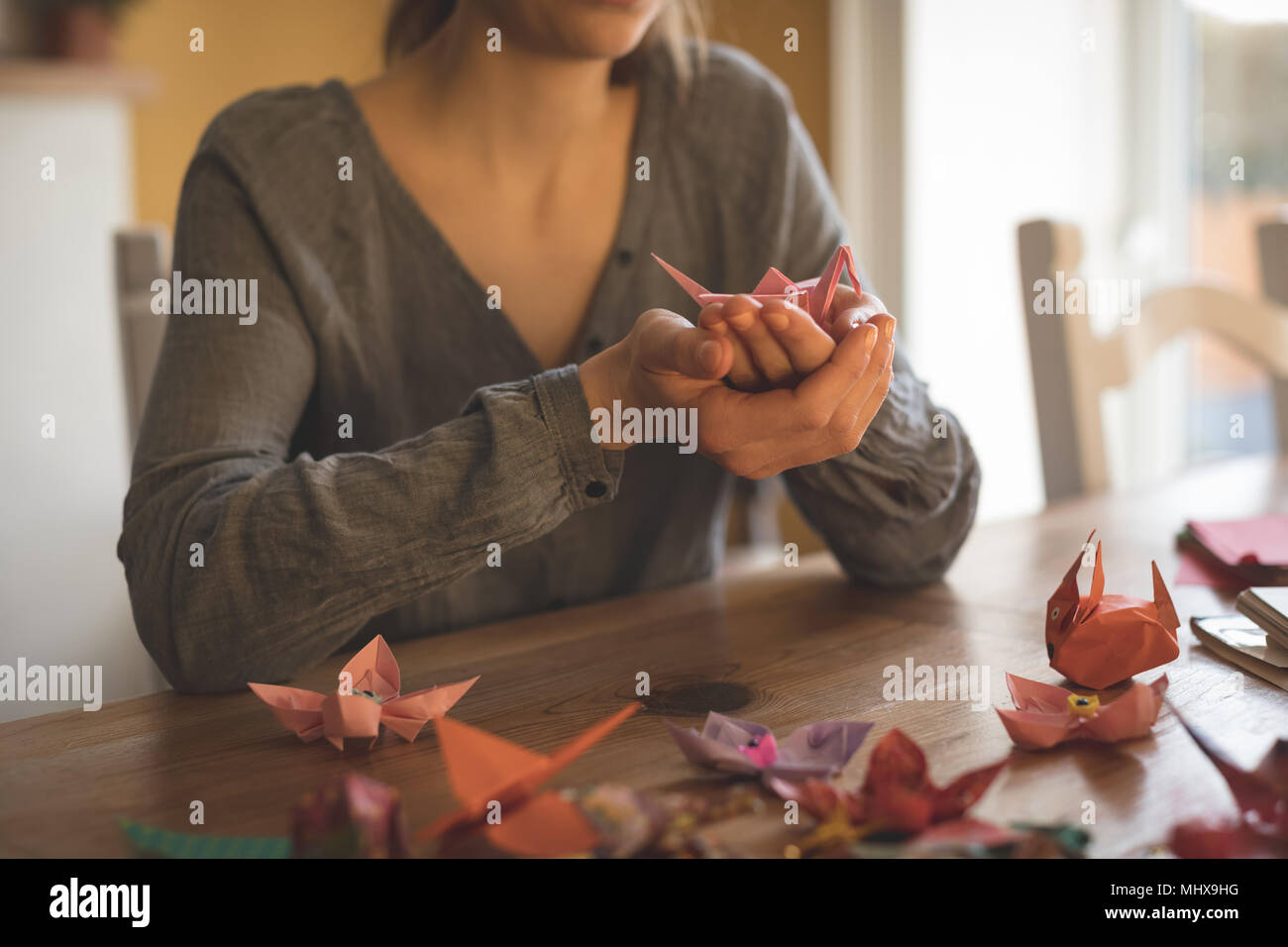 Woman showing origami at home Stock Photo - Alamy