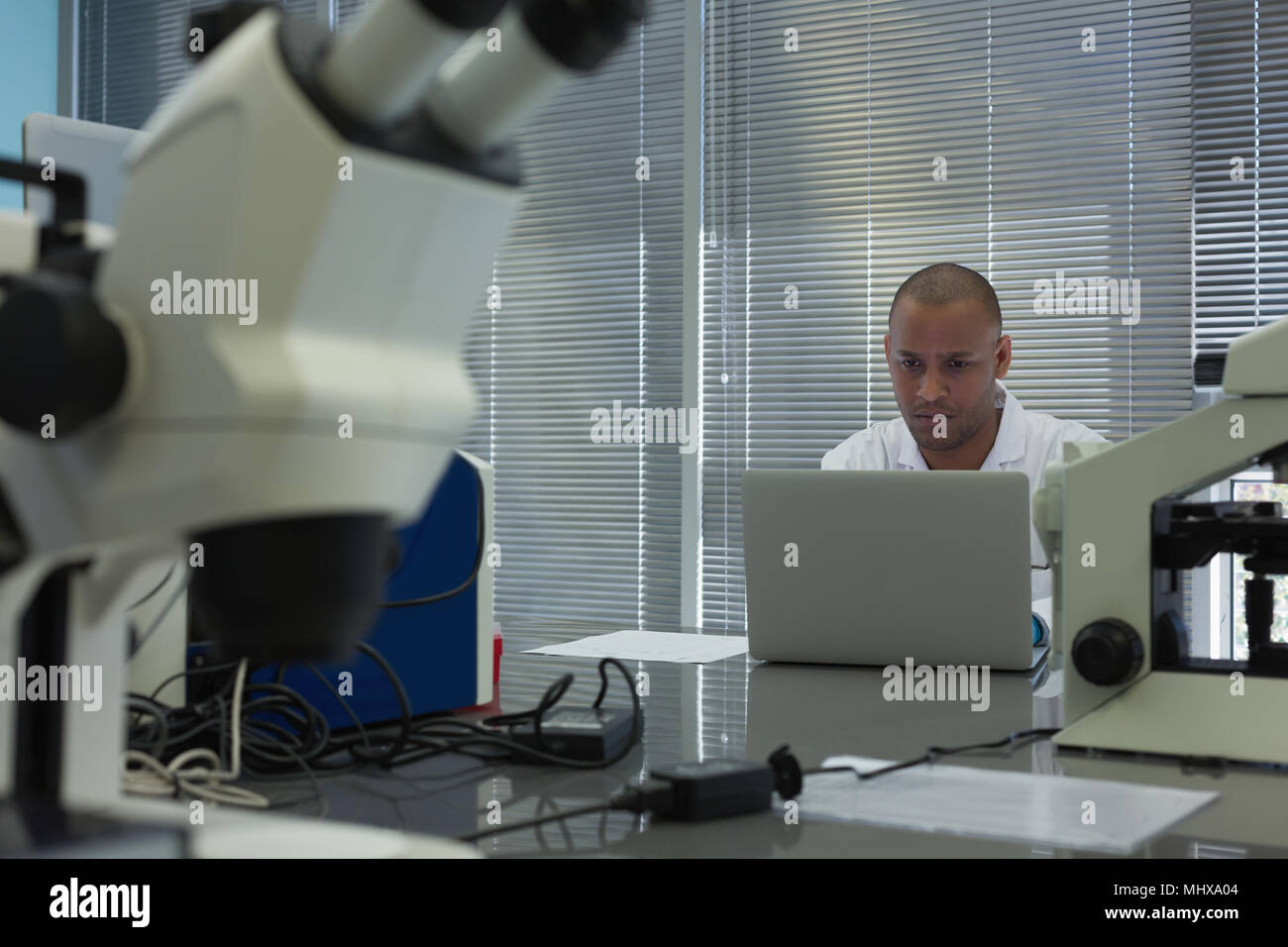 Scientist using laptop at desk Stock Photo - Alamy