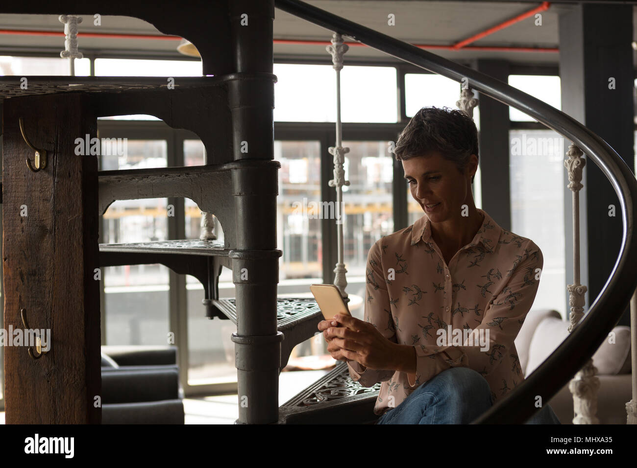 Businesswoman using mobile phone on staircase Stock Photo - Alamy