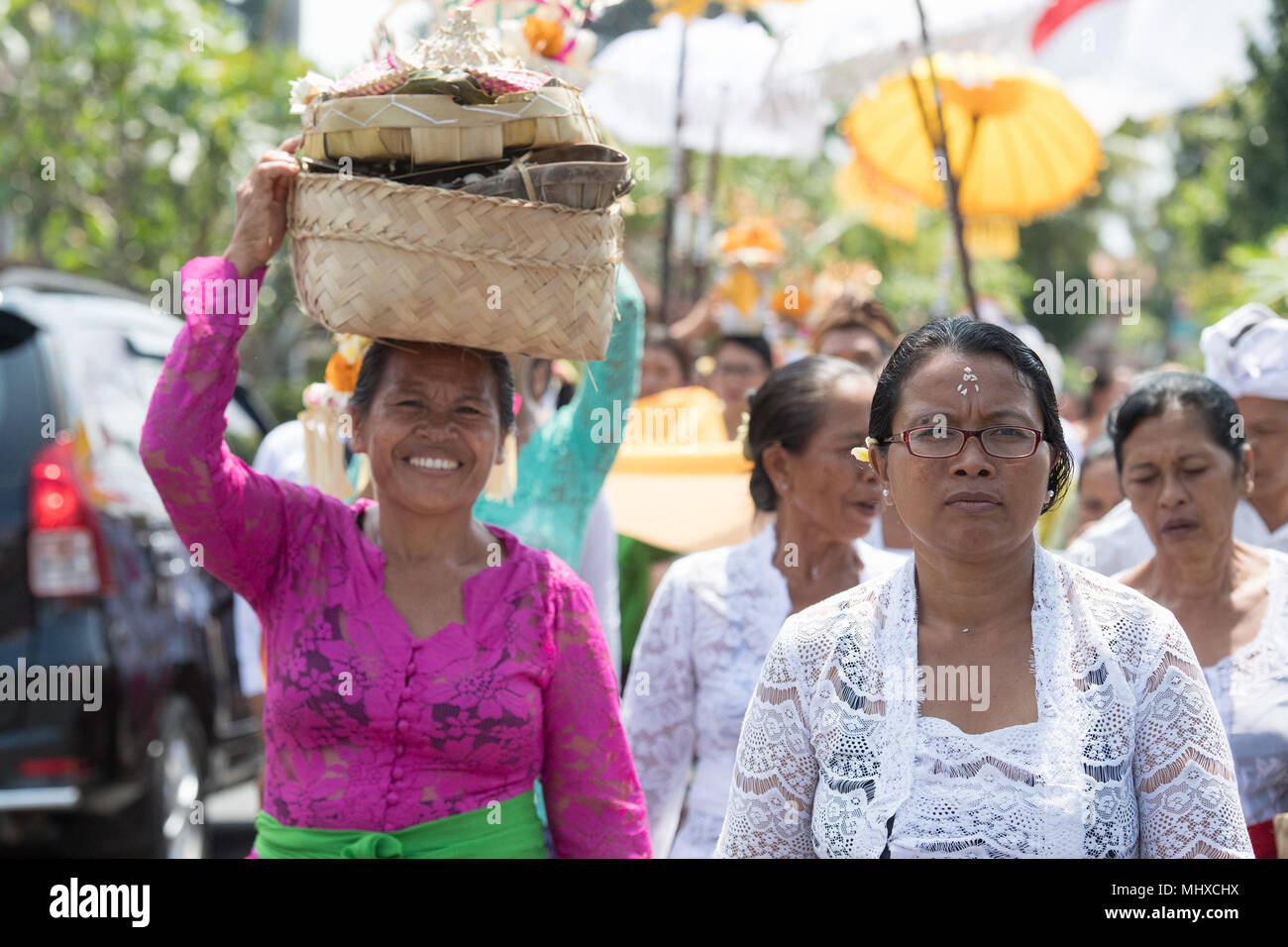 BALI, INDONESIA - AUGUST 17, 2016 - Balinese monk and worshipper with ...