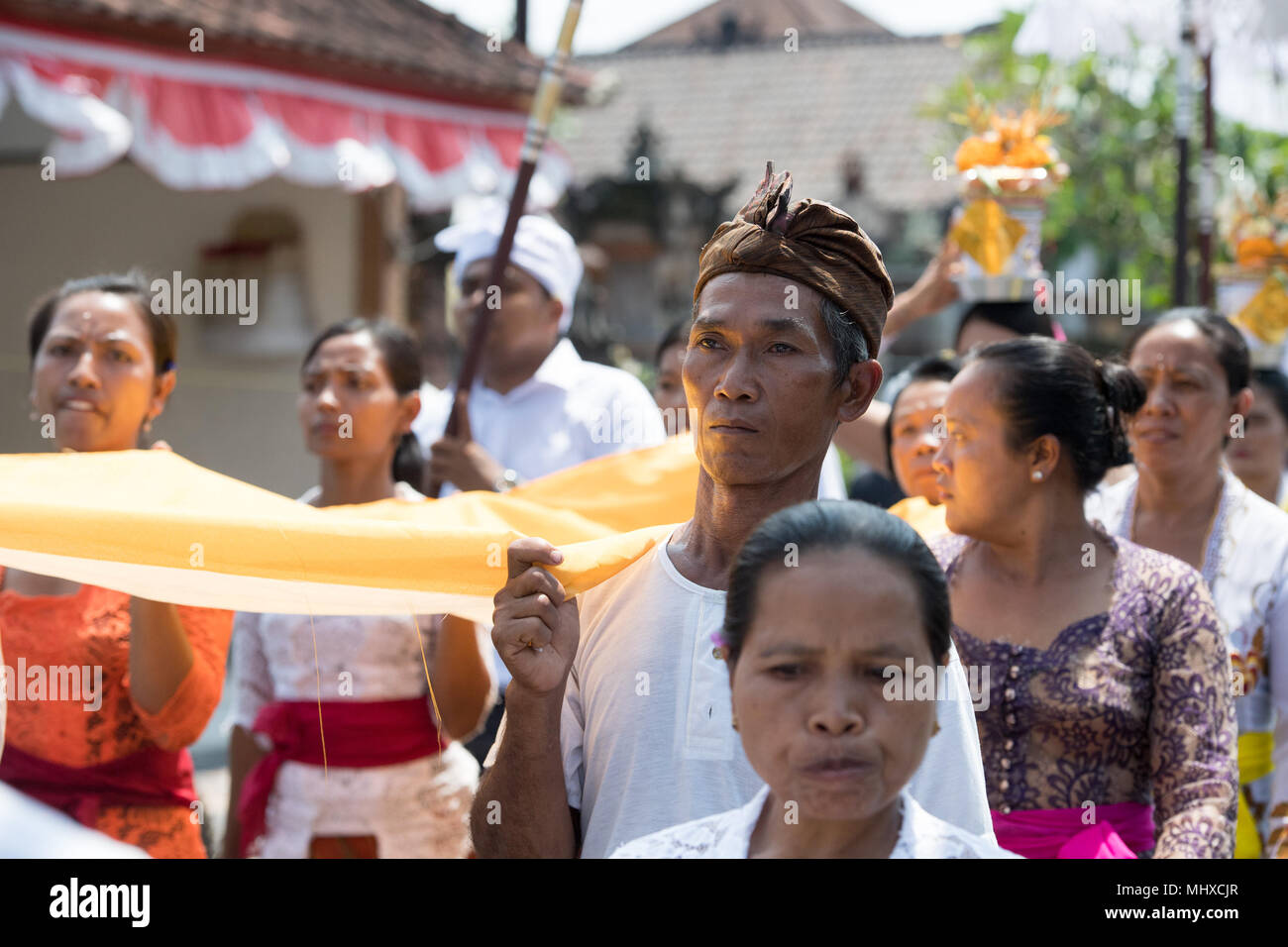 BALI, INDONESIA - AUGUST 17, 2016 - Balinese monk and worshipper with ...