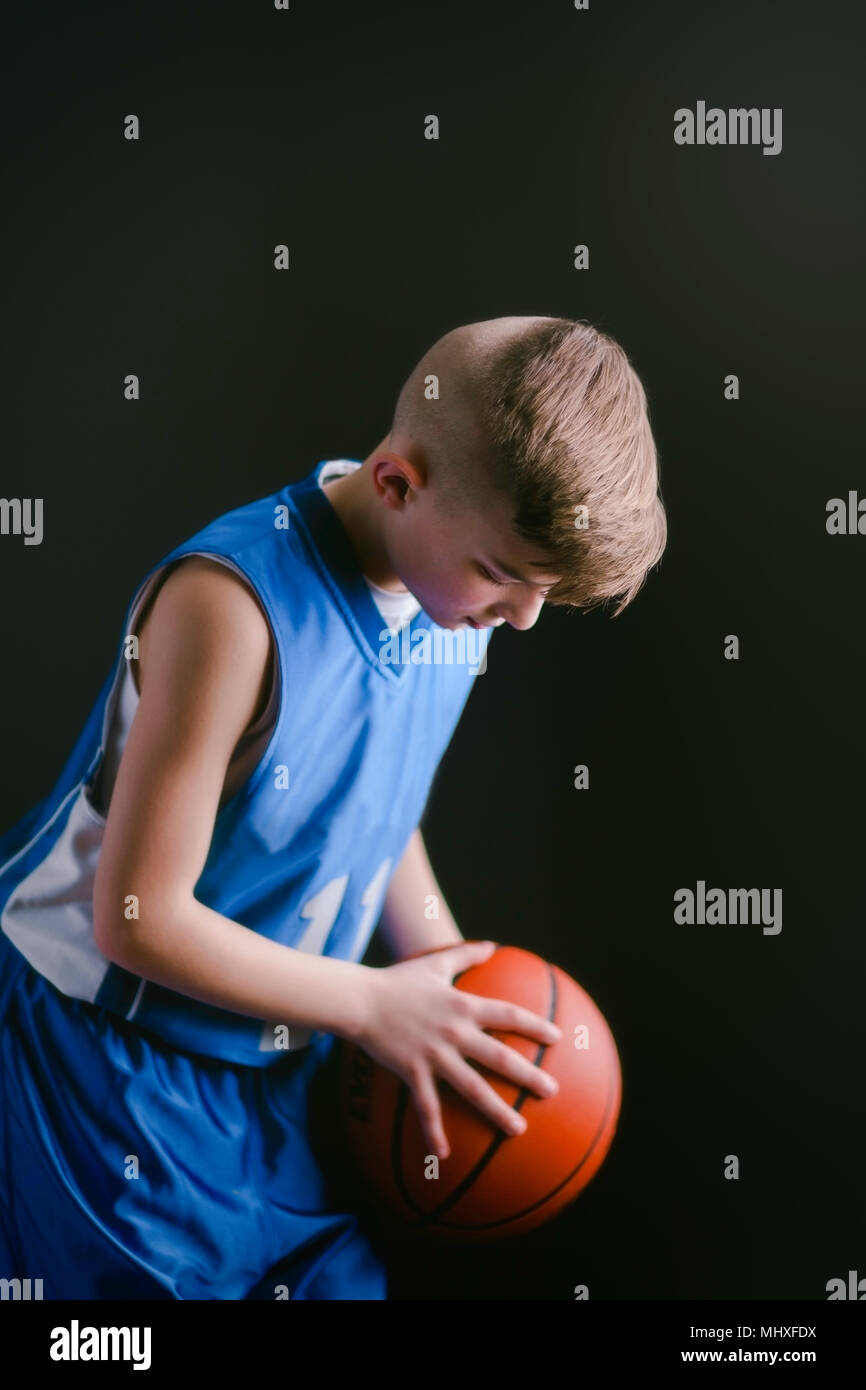 Boy bouncing basketball Stock Photo - Alamy