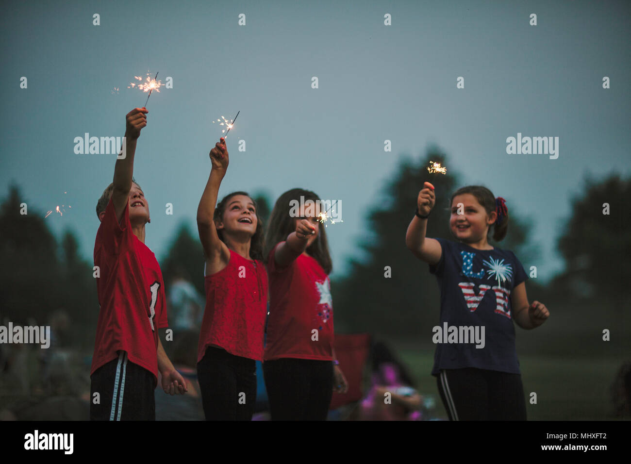 Group of friends, arms raised holding sparklers Stock Photo - Alamy