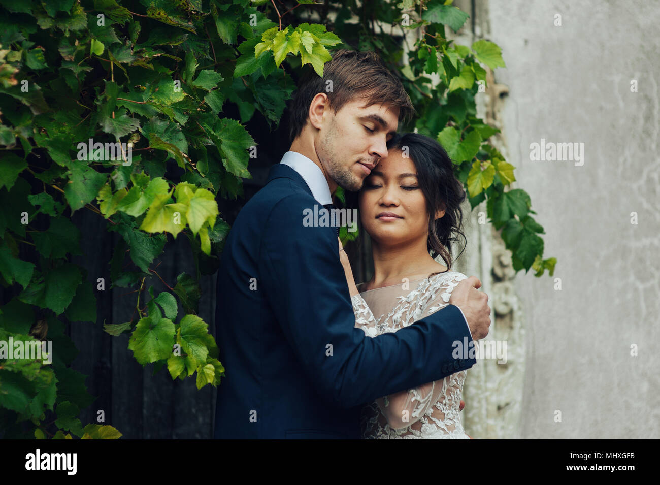 Portrait of elegant asian bride hugging groom Stock Photo - Alamy