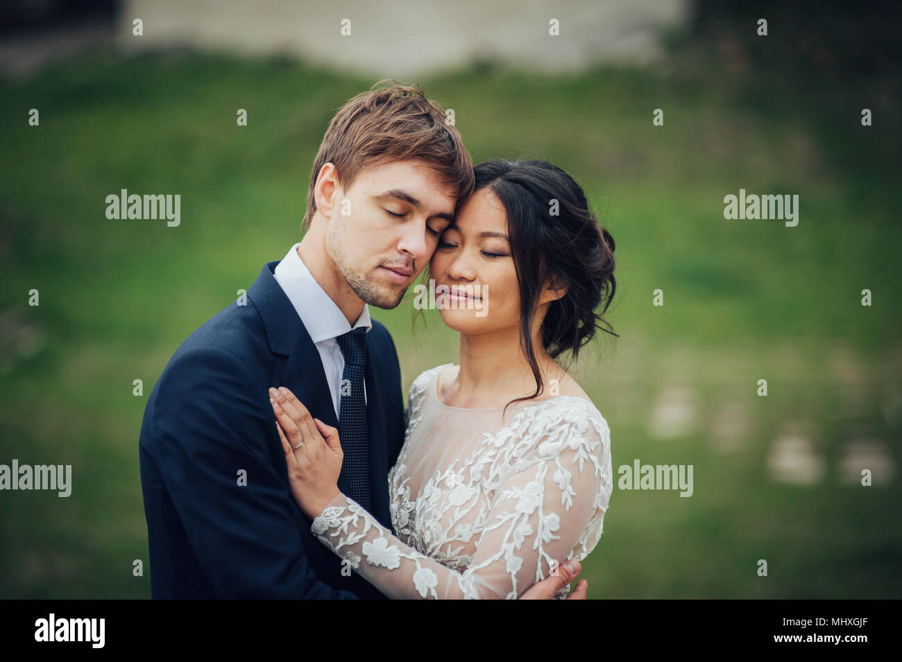 Portrait of elegant asian bride hugging groom Stock Photo - Alamy
