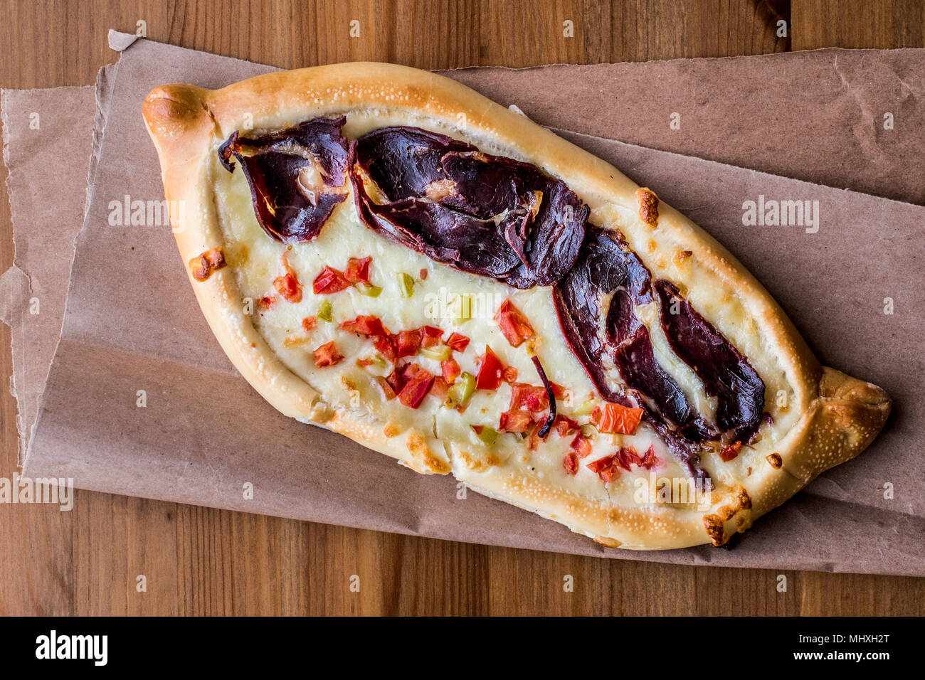 Turkish Pide with Pastirma , tomato and melted cheese on a wooden ...