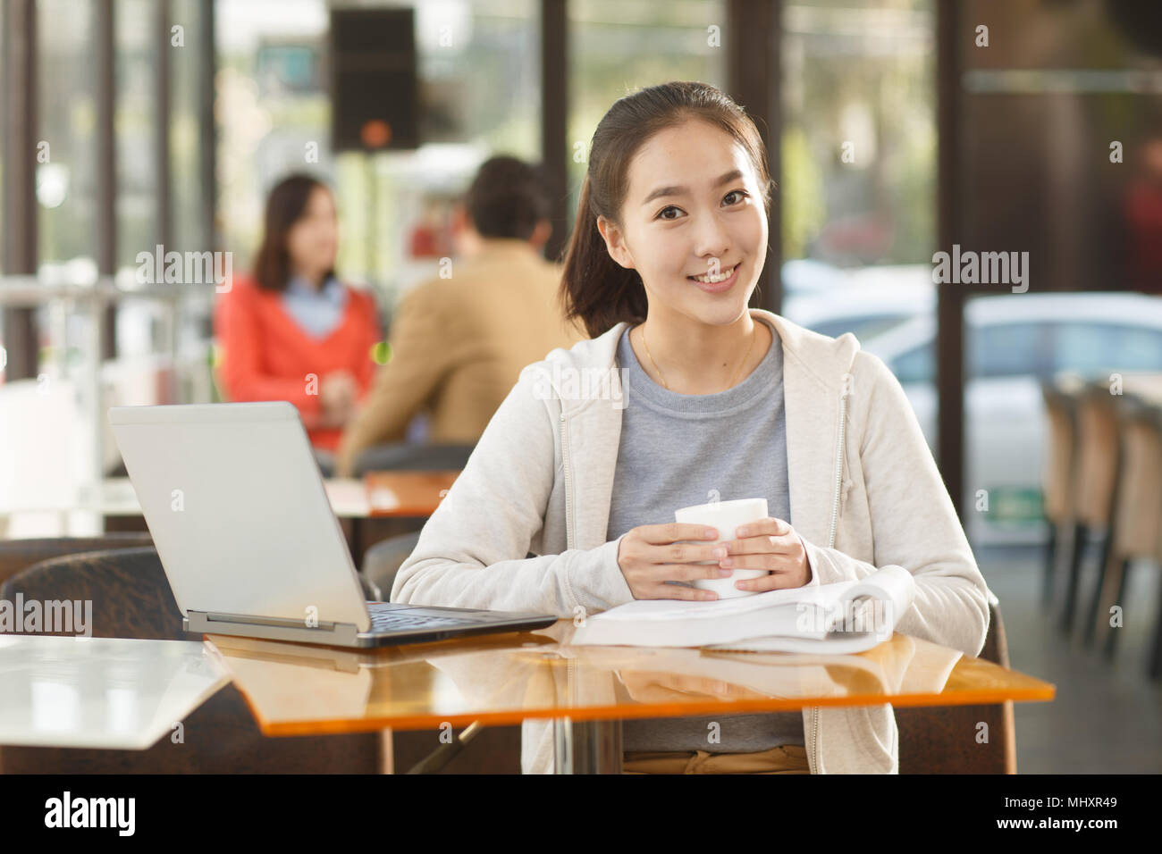 Young women study in coffee shop Stock Photo - Alamy