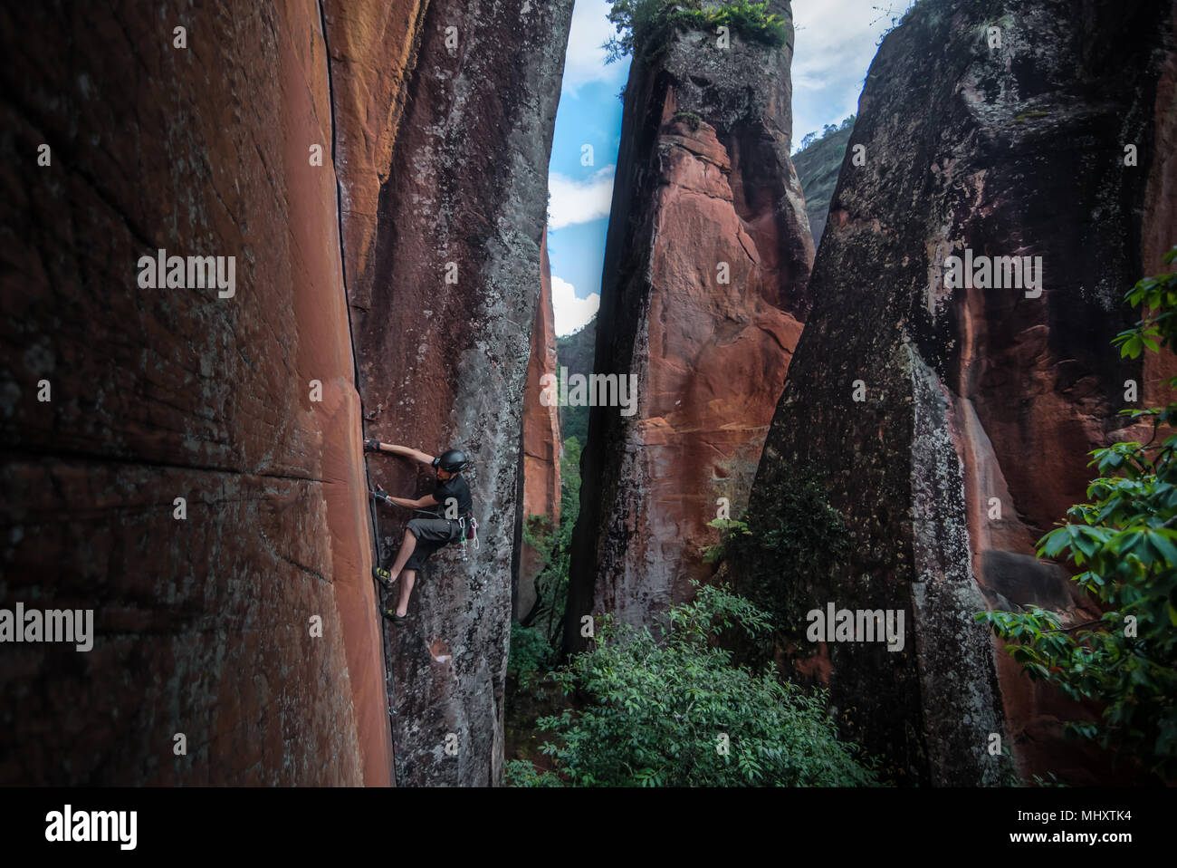 Rock climbers climbing sandstone rock, Liming, Yunnan Province, China ...