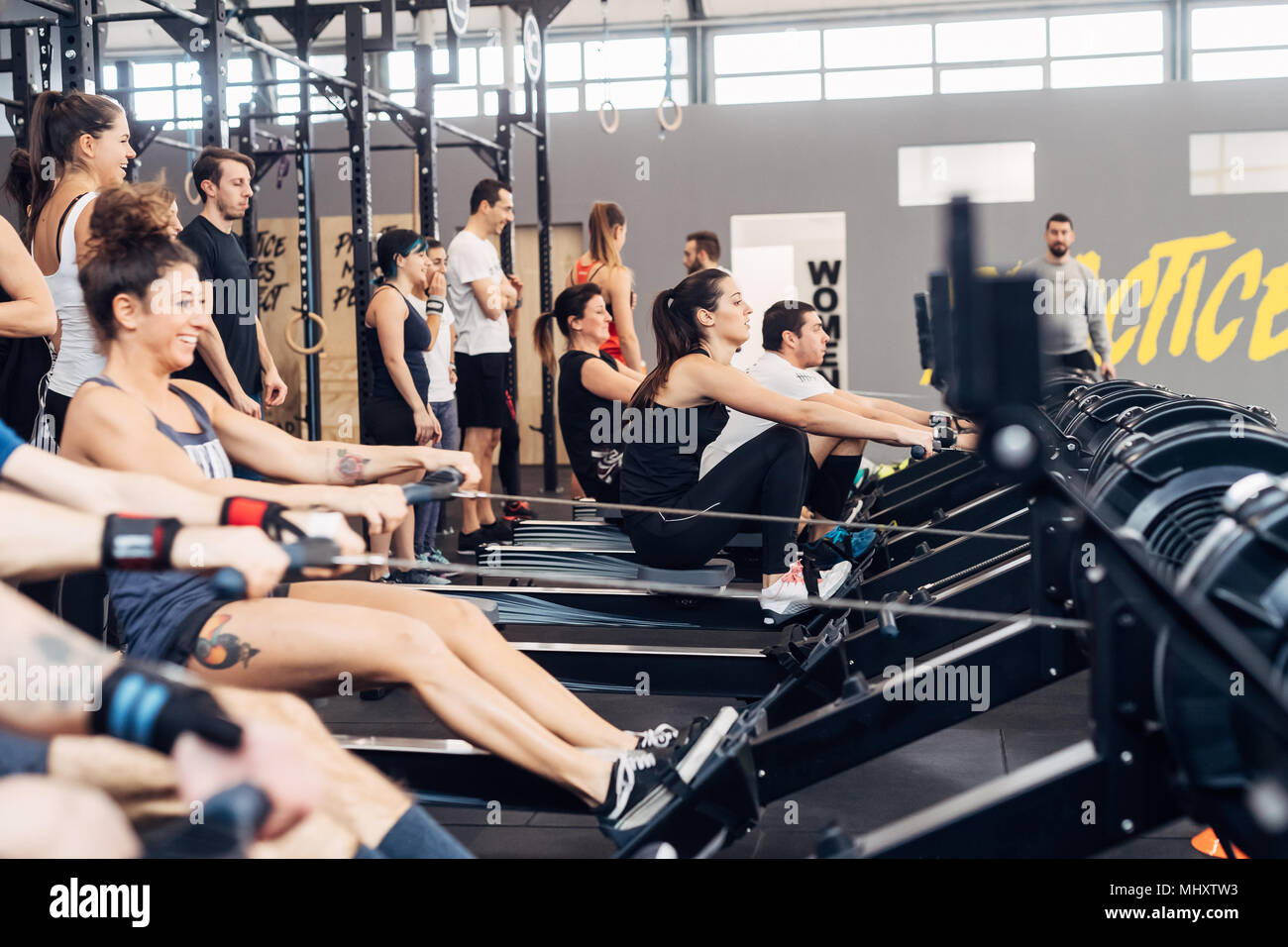Large group of people using rowing machine in gym Stock Photo - Alamy