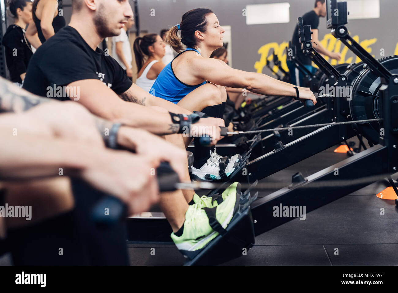 Large group of people using rowing machine in gym Stock Photo - Alamy