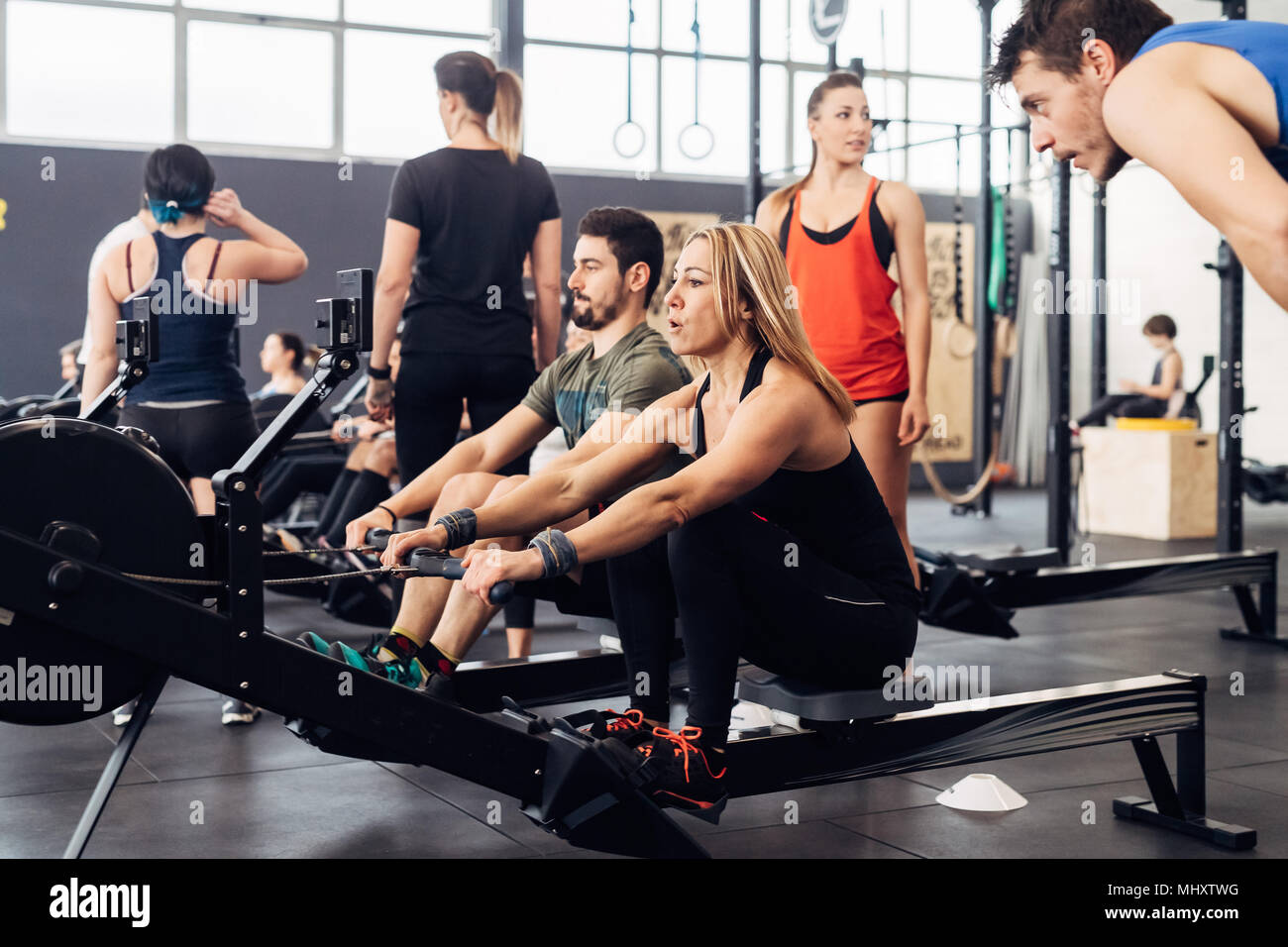People using rowing machines in in gym Stock Photo - Alamy
