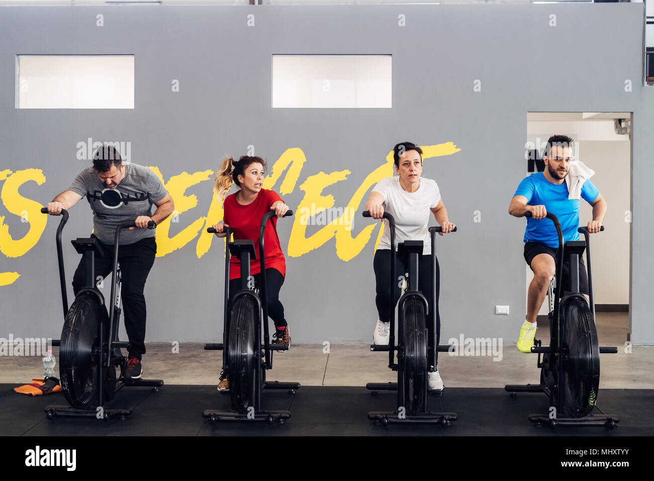 People in gym using exercise bikes Stock Photo - Alamy