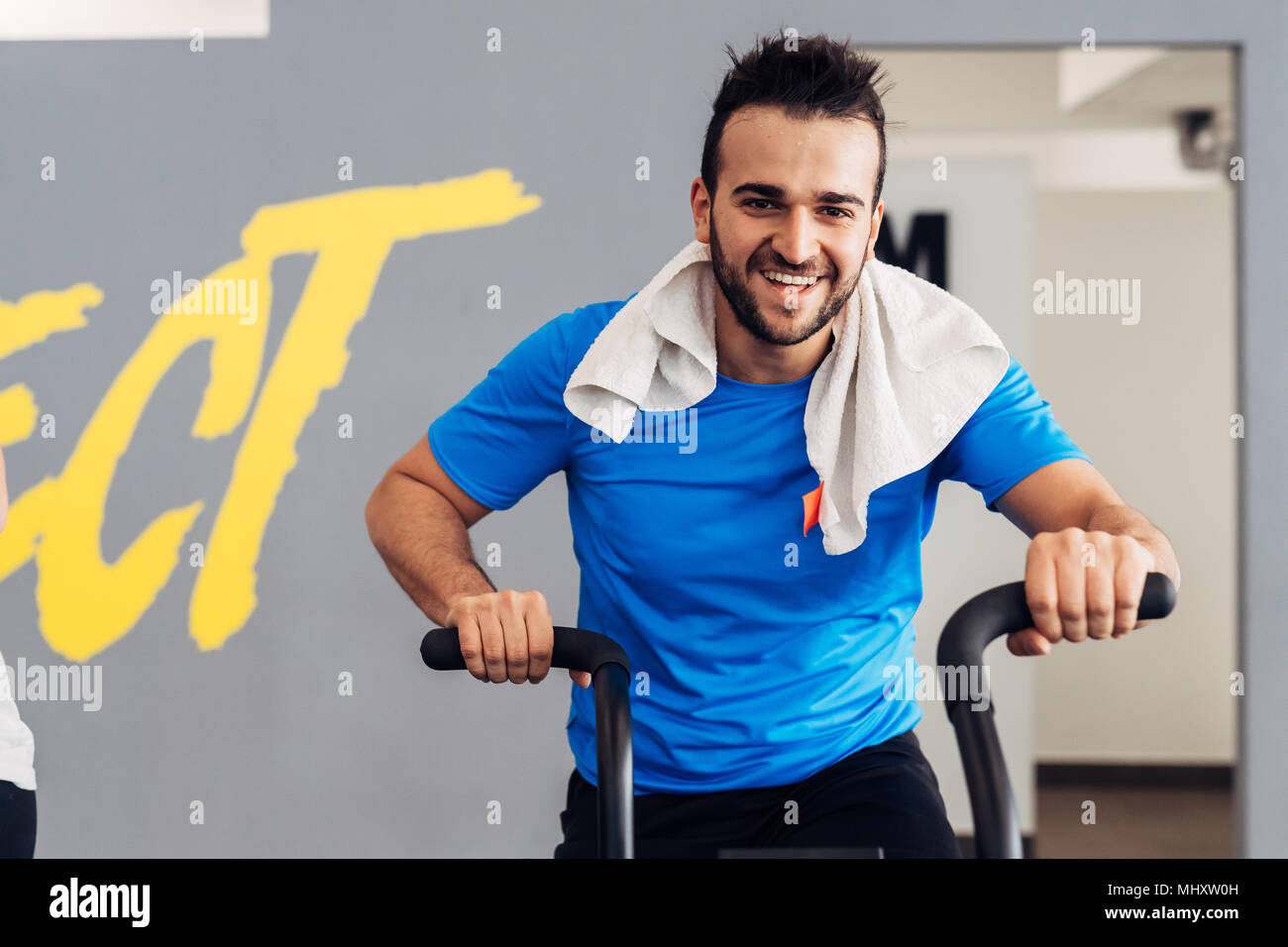 Man in gym using exercise bike Stock Photo - Alamy