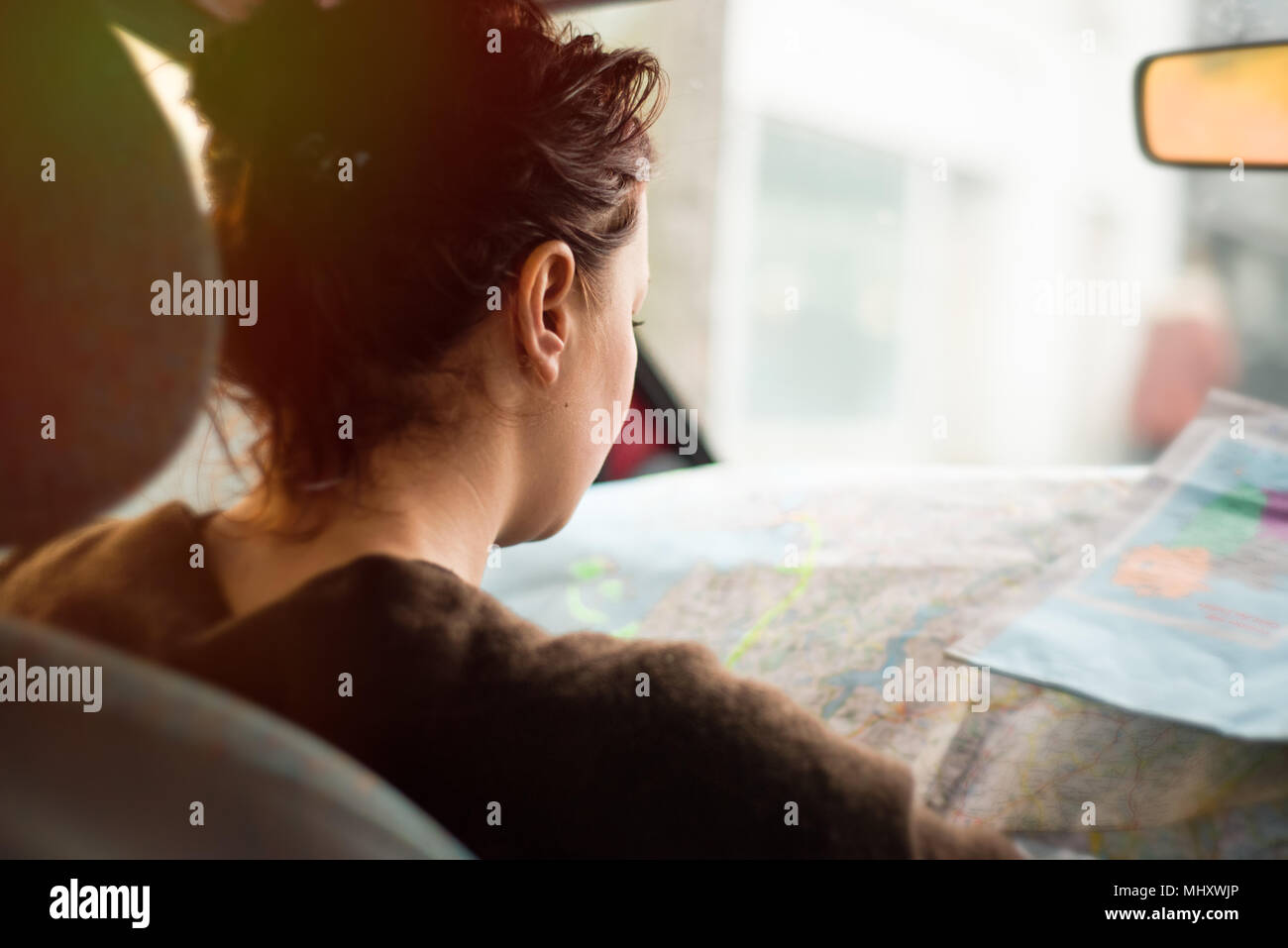 Woman map reading in car Stock Photo - Alamy