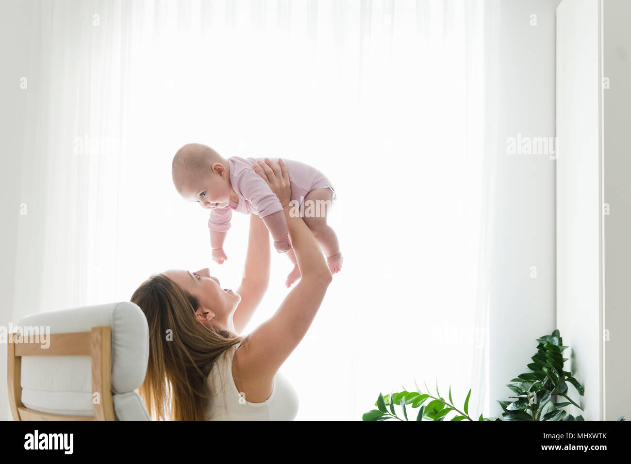 Mother lifting baby up Stock Photo - Alamy