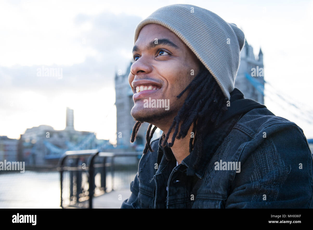 Portrait of young man sitting outdoors, smiling, London, England, UK ...
