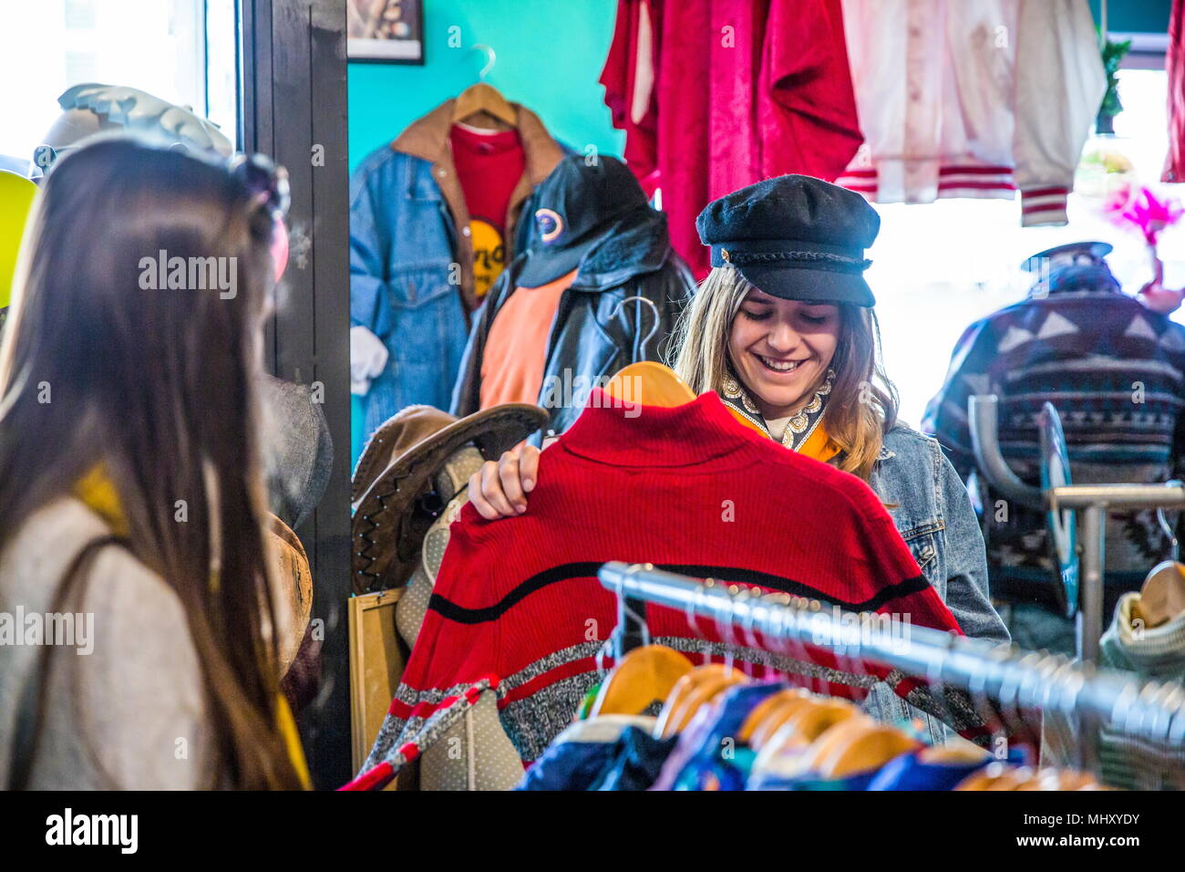 Friends browsing vintage clothes in thrift store Stock Photo - Alamy