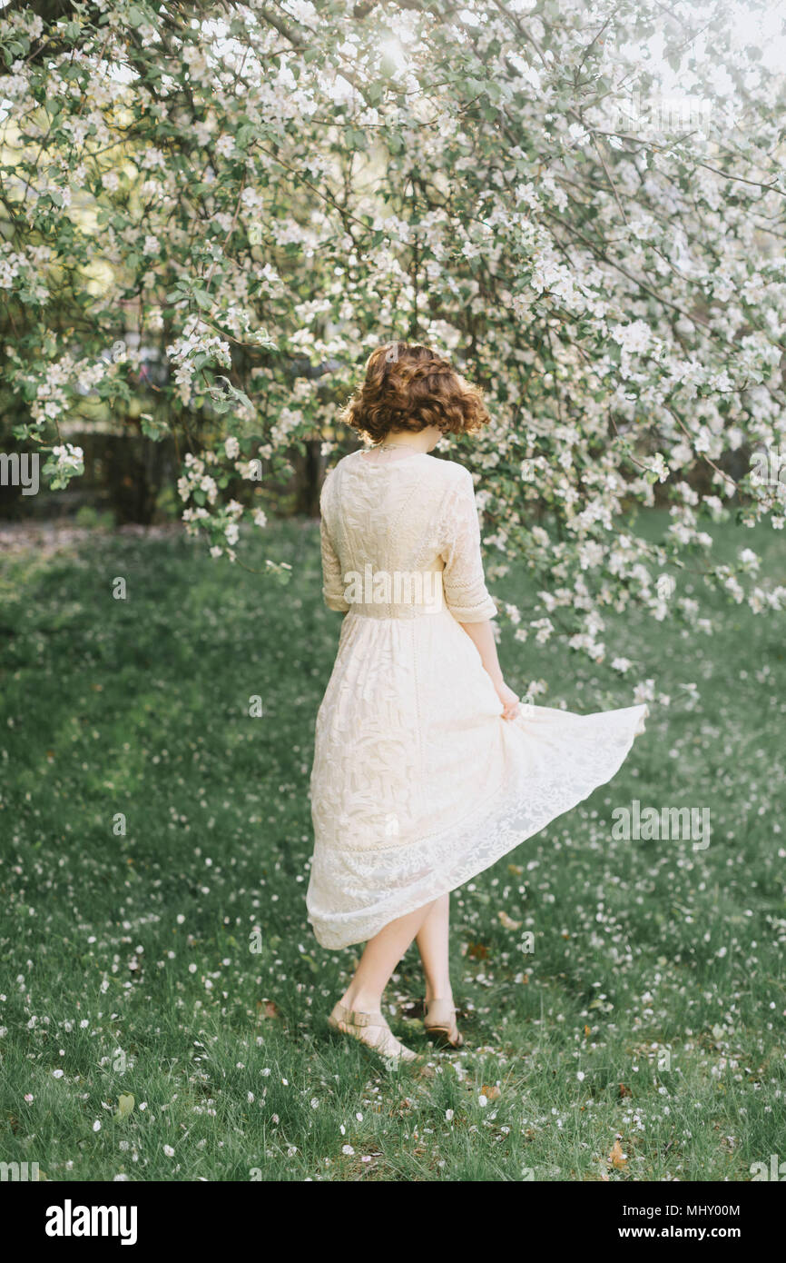 Woman twirling by blossom tree Stock Photo - Alamy