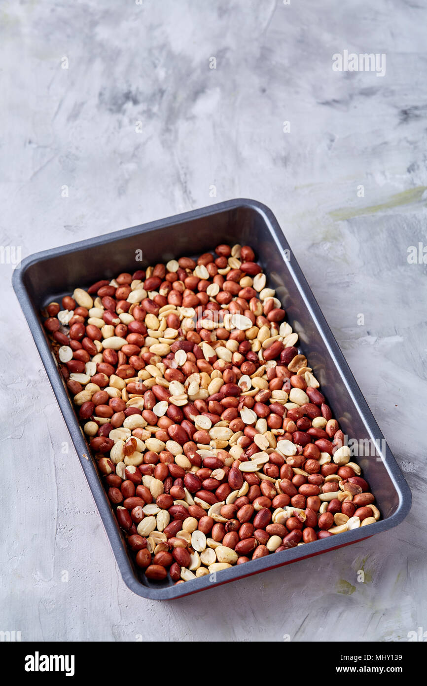 Mix of raw shelled peanuts in wooden plate isolated over white textured ...