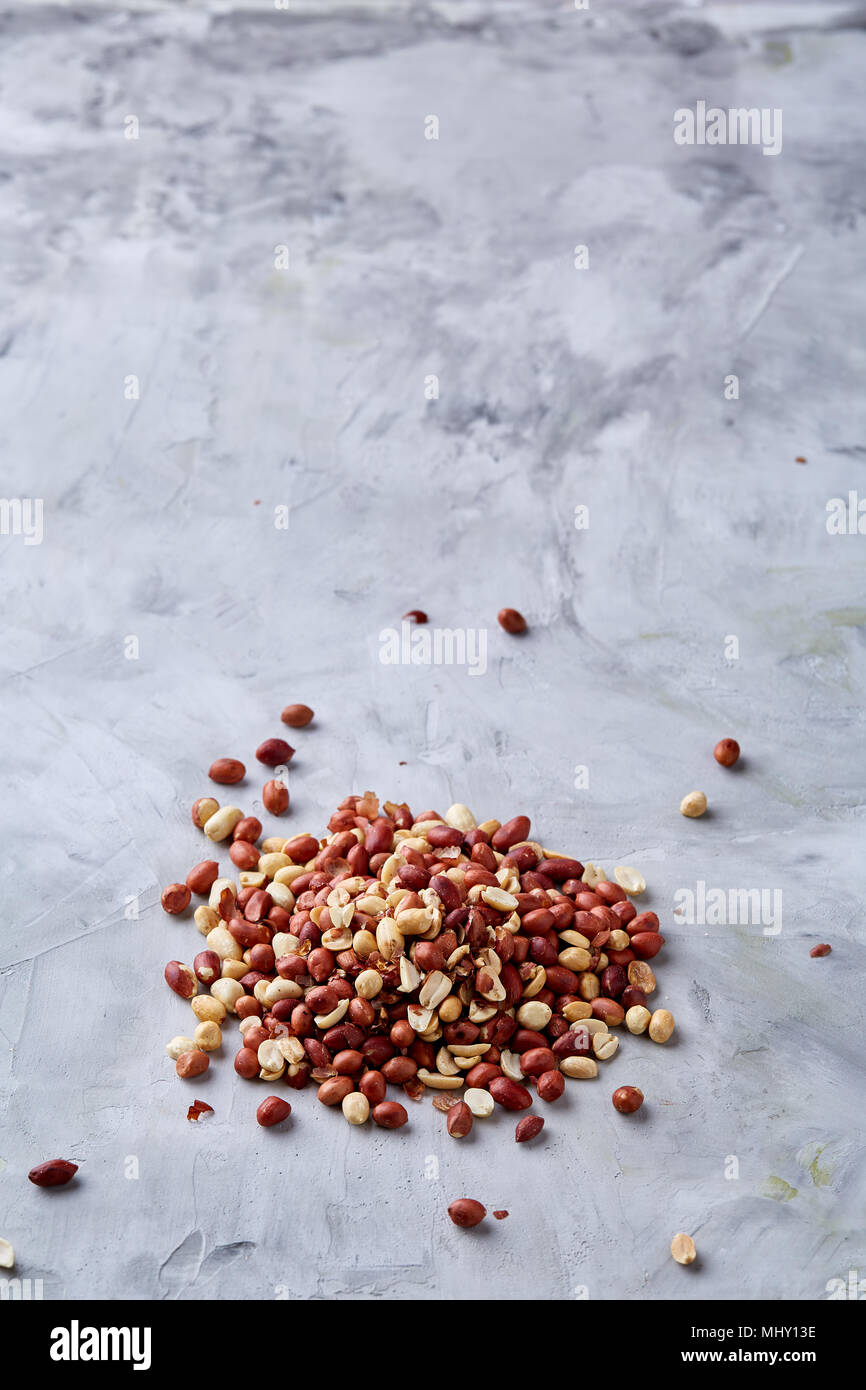 Mix of raw shelled peanuts in wooden plate isolated over white textured ...