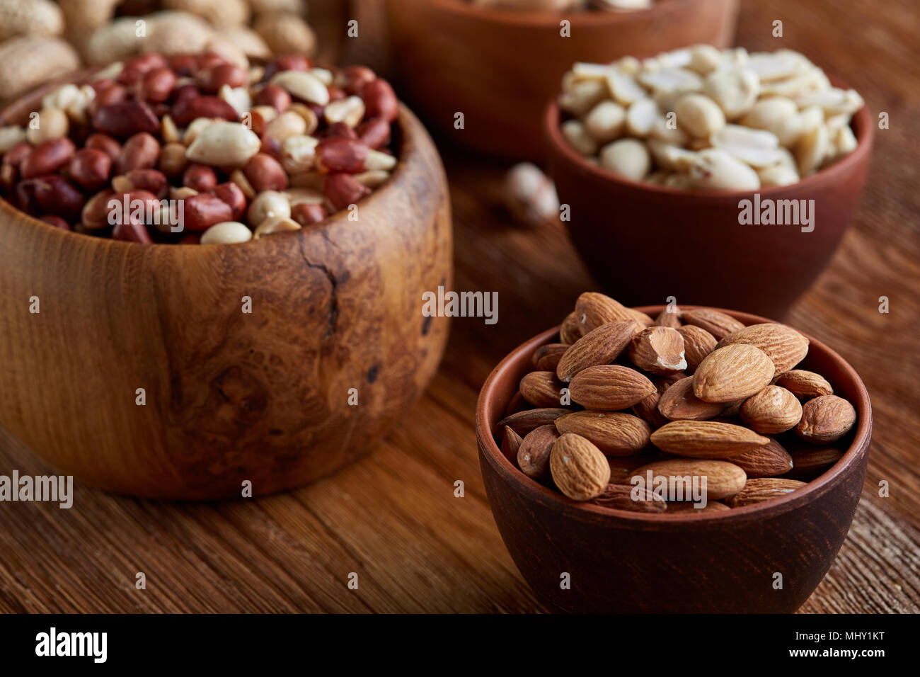 A composition from different varieties of nuts in a wooden bowls over ...