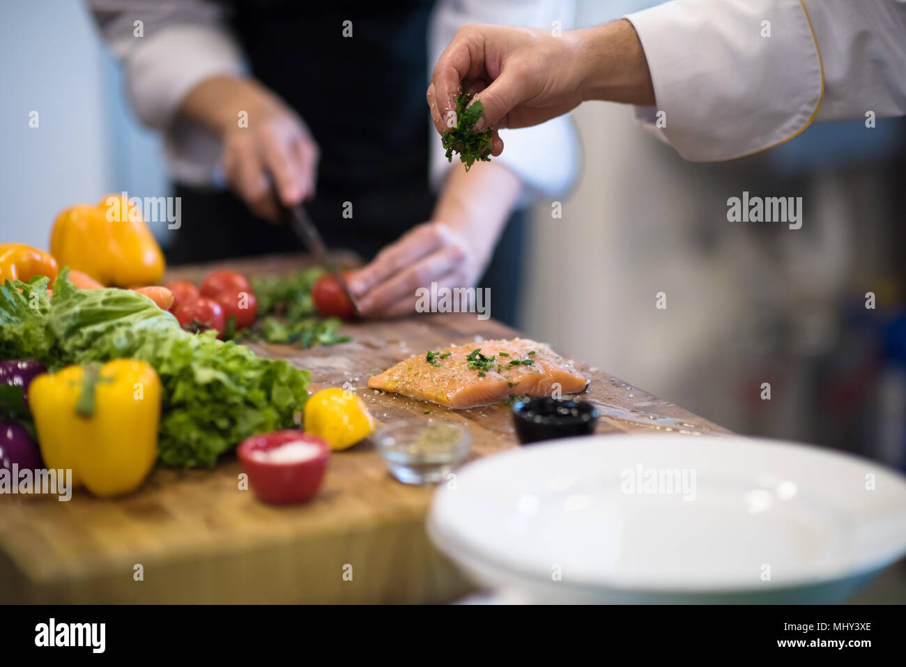 Chef hands preparing marinated Salmon fish fillet for frying in a ...