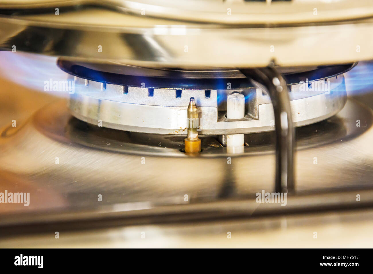 Focus of blue flame gas on a cooker boiling pot in kitchen gas stove ...