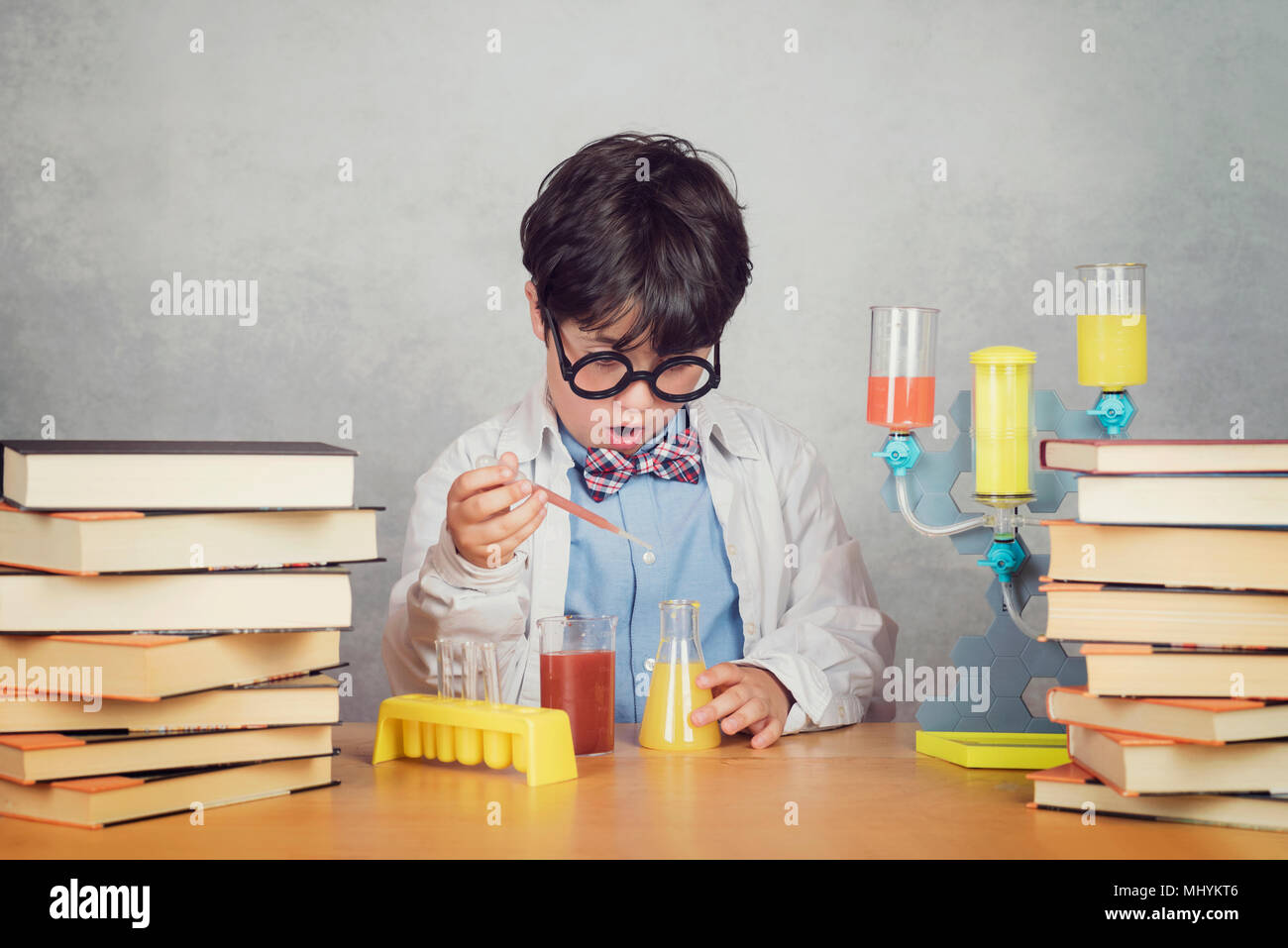 boy is making science experiments in a laboratory on gray background ...