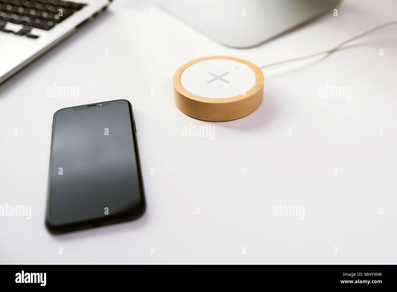 Mobile phone and wireless charger on office table. Future technology ...